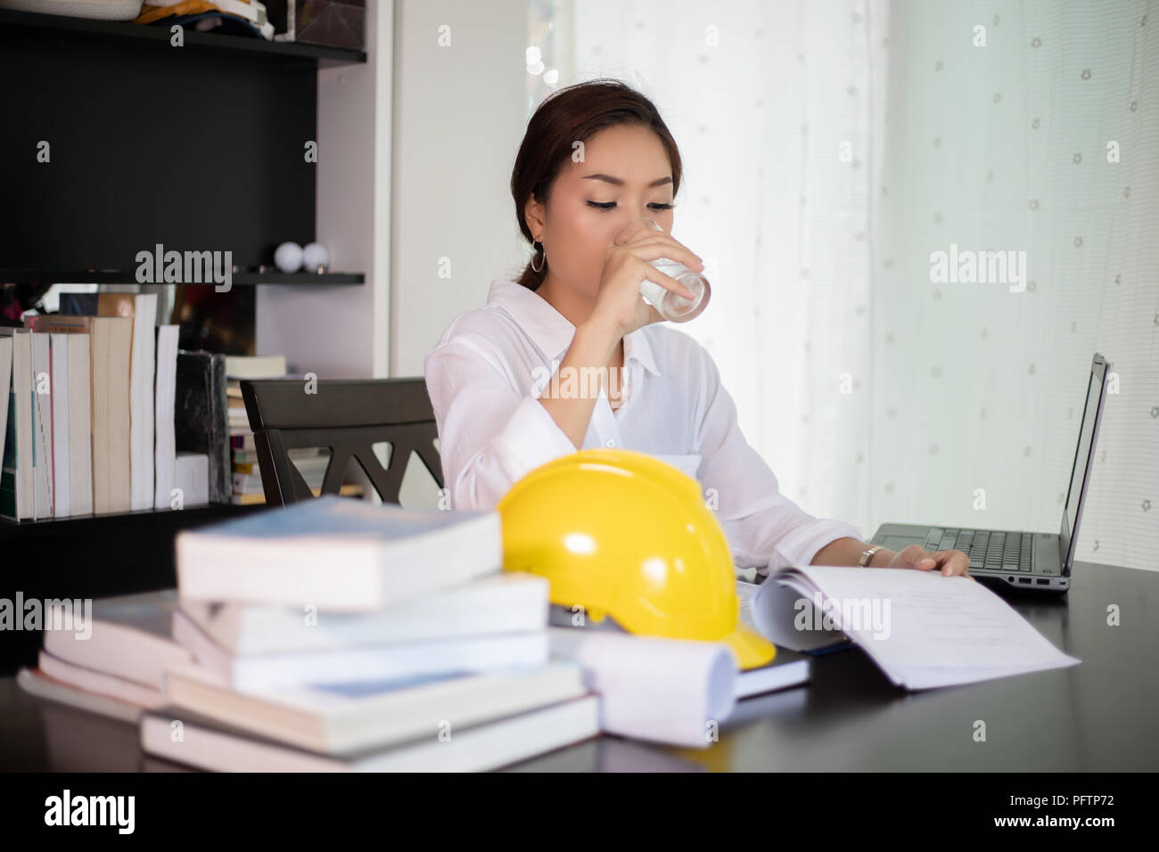 Asian women engineer are drinking water and working at office Stock ...