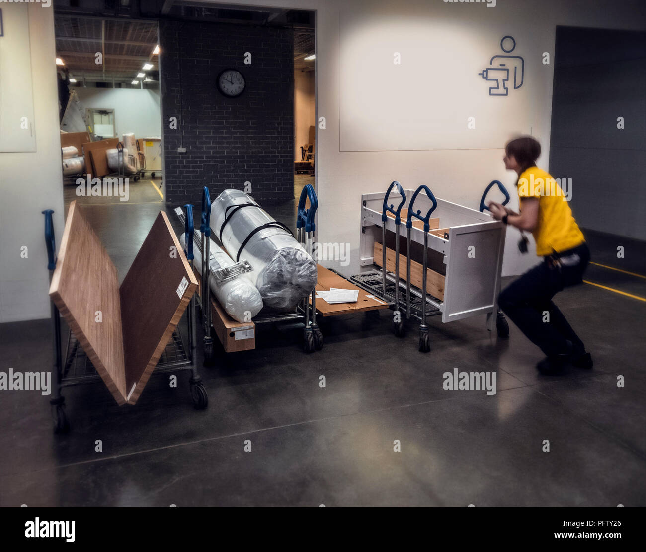 worker pushes a carts with furniture in the storehouse Stock Photo - Alamy