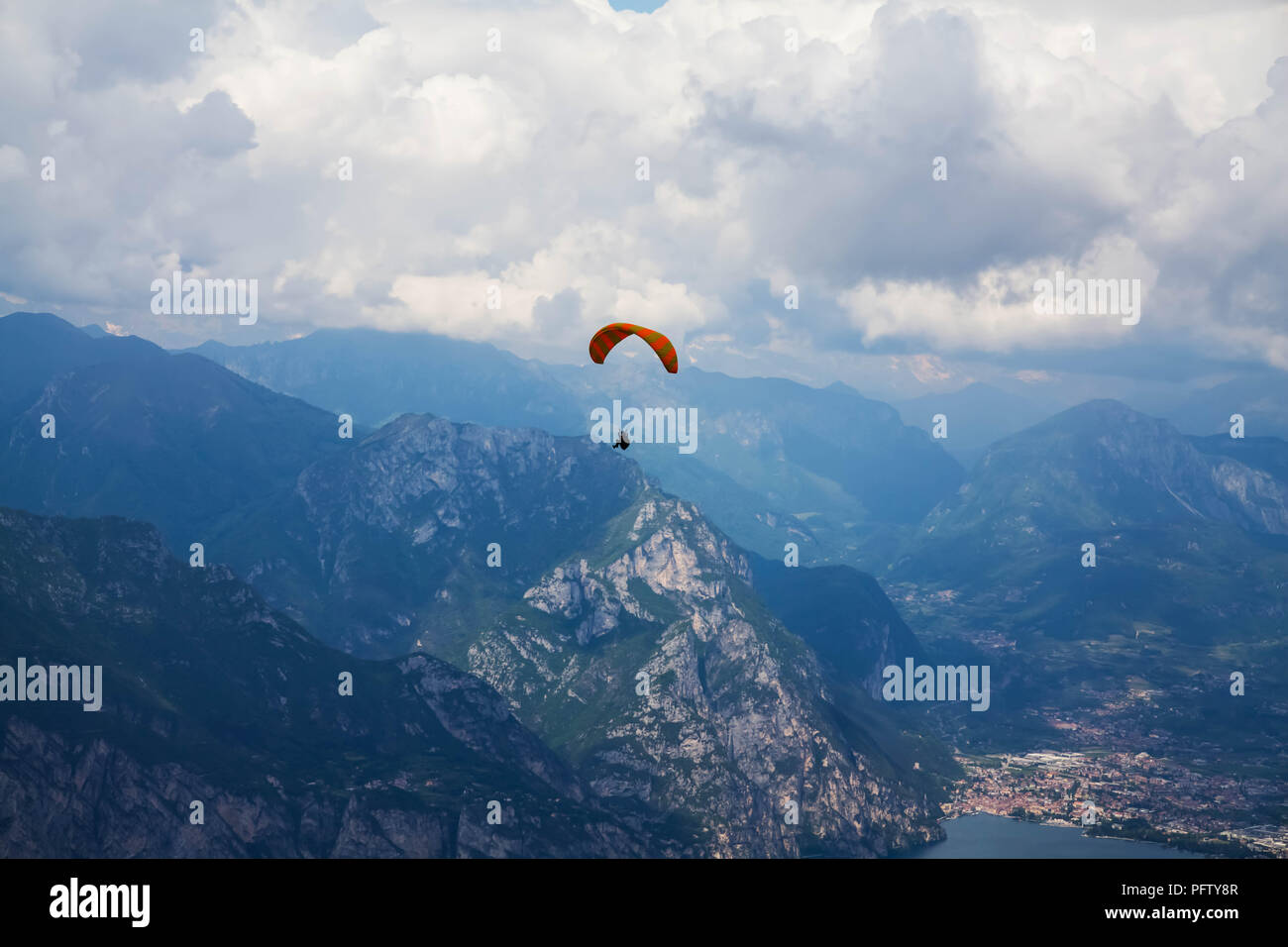 Paraglider flying over mountains and lake in summer day Stock Photo - Alamy