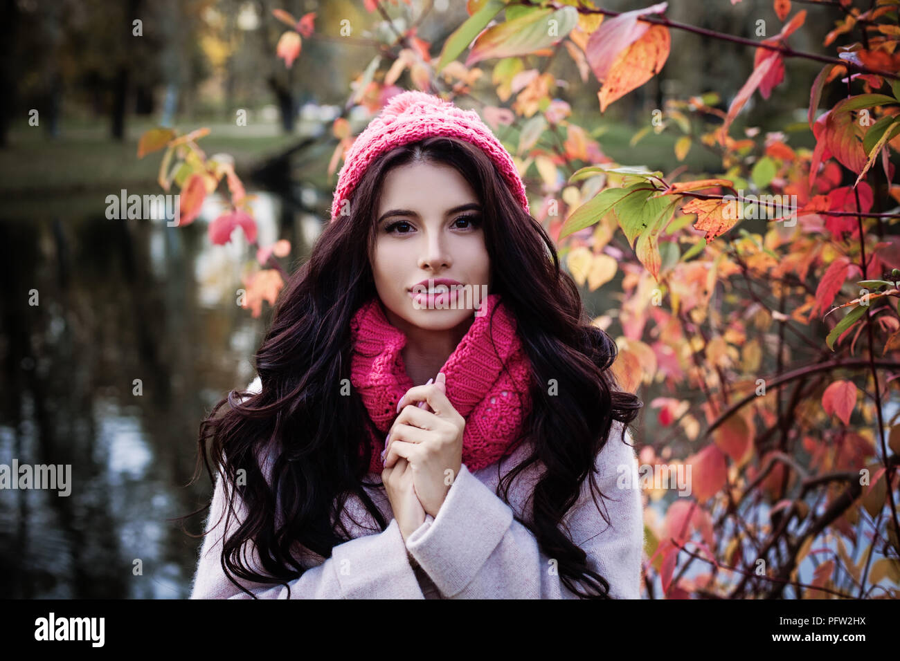 Autumn woman brunette in red maple leaves outdoors. Beautiful girl in ...