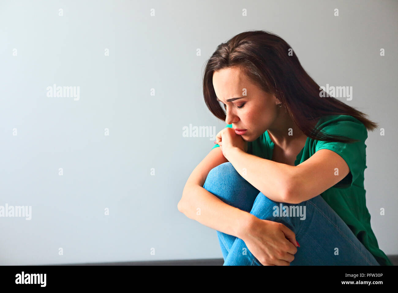 Portrait of a sad woman looking thoughtful about her troubles in front ...