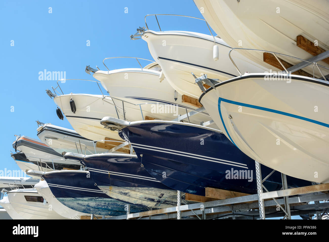 View from below of the hulls of motorboats racked one above another on ...
