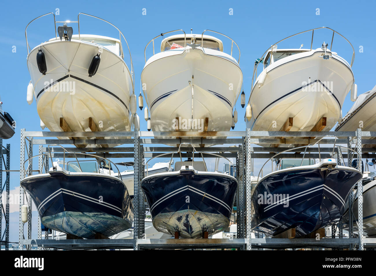 View from below of the hulls of motorboats racked one above another on ...