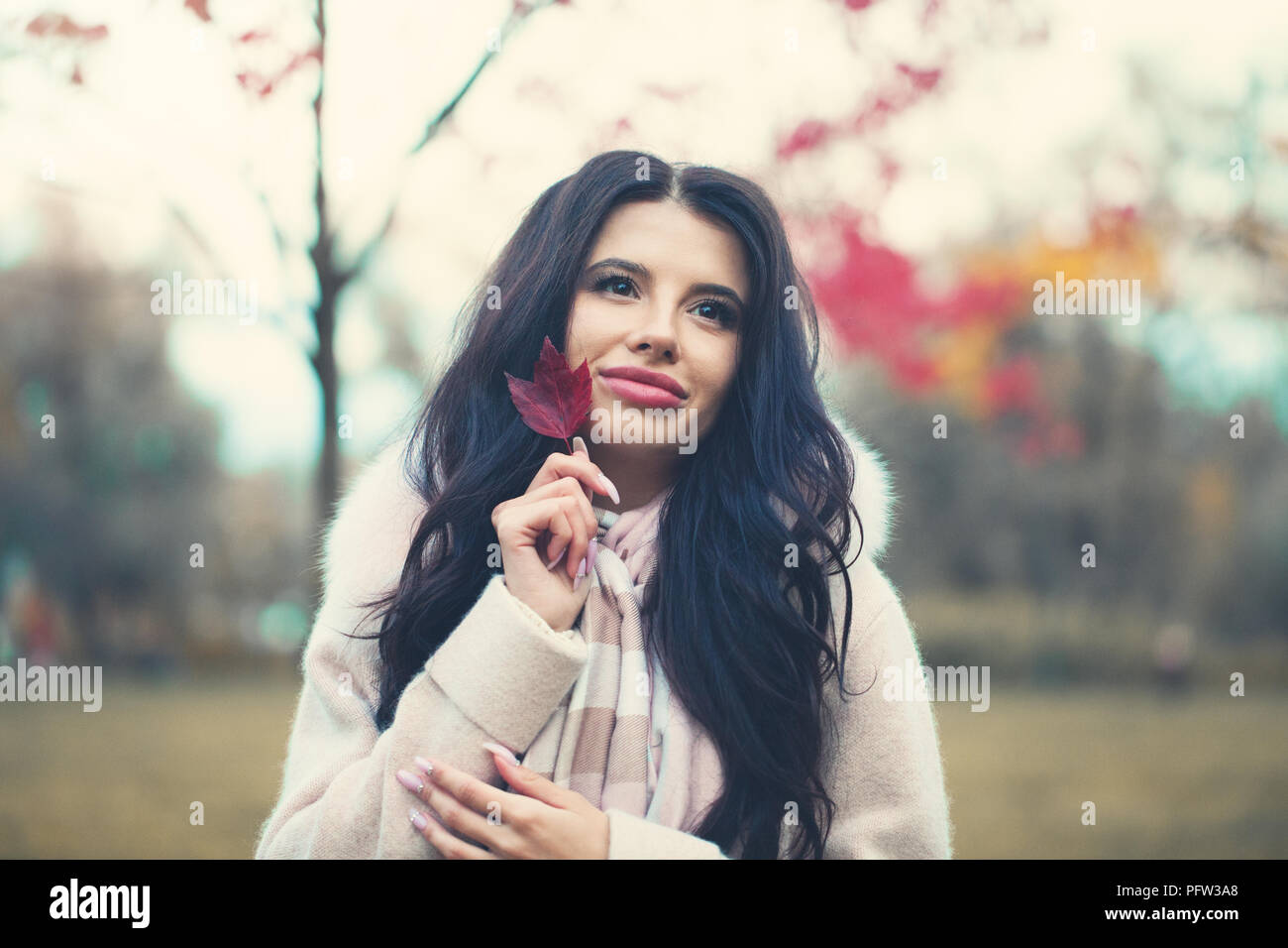 Autumn woman portrait. Perfect female model with red maple leaf outdoor ...