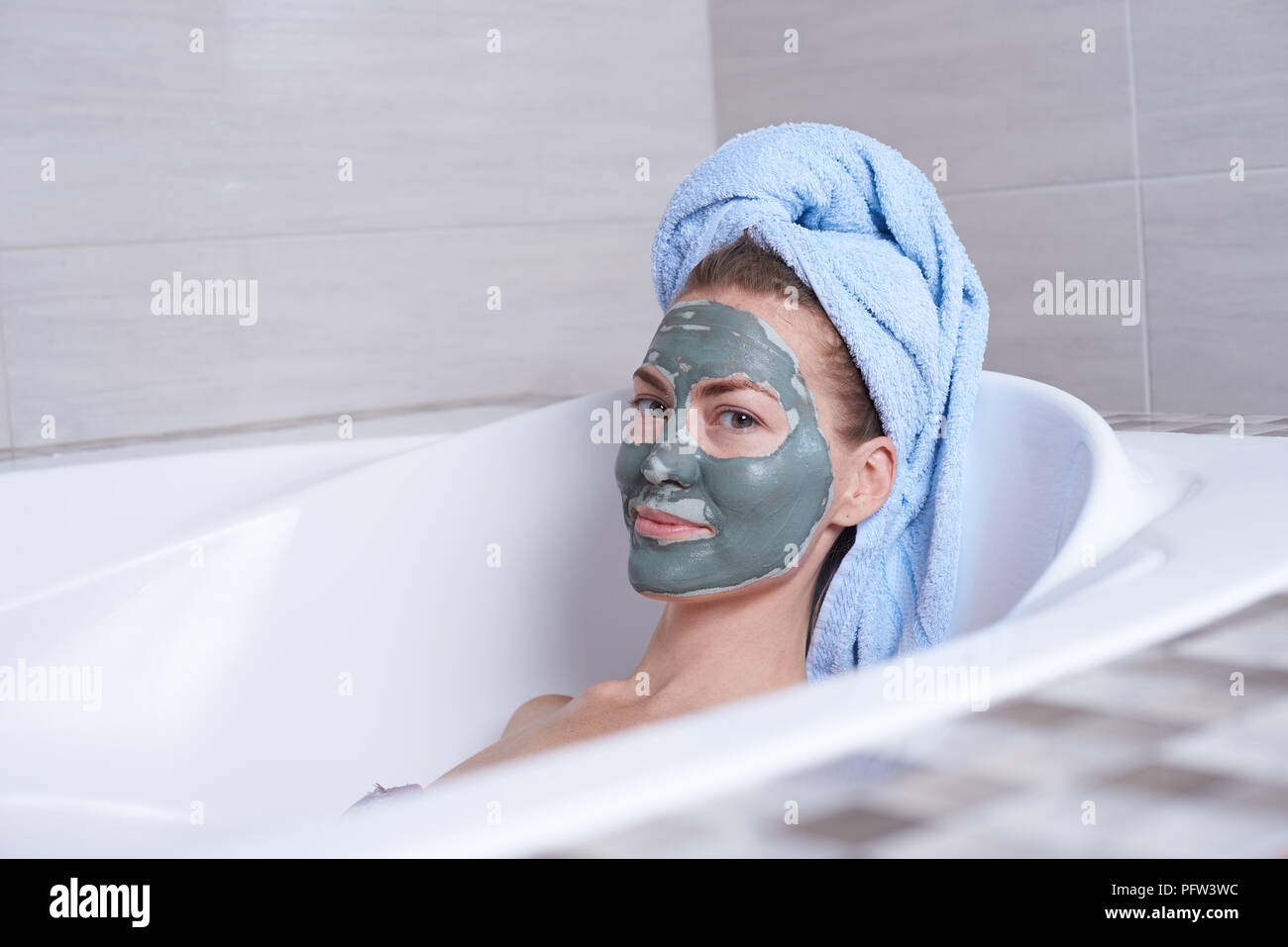 Portrait of a woman in facial alginate mask lying in the retro bath in ...