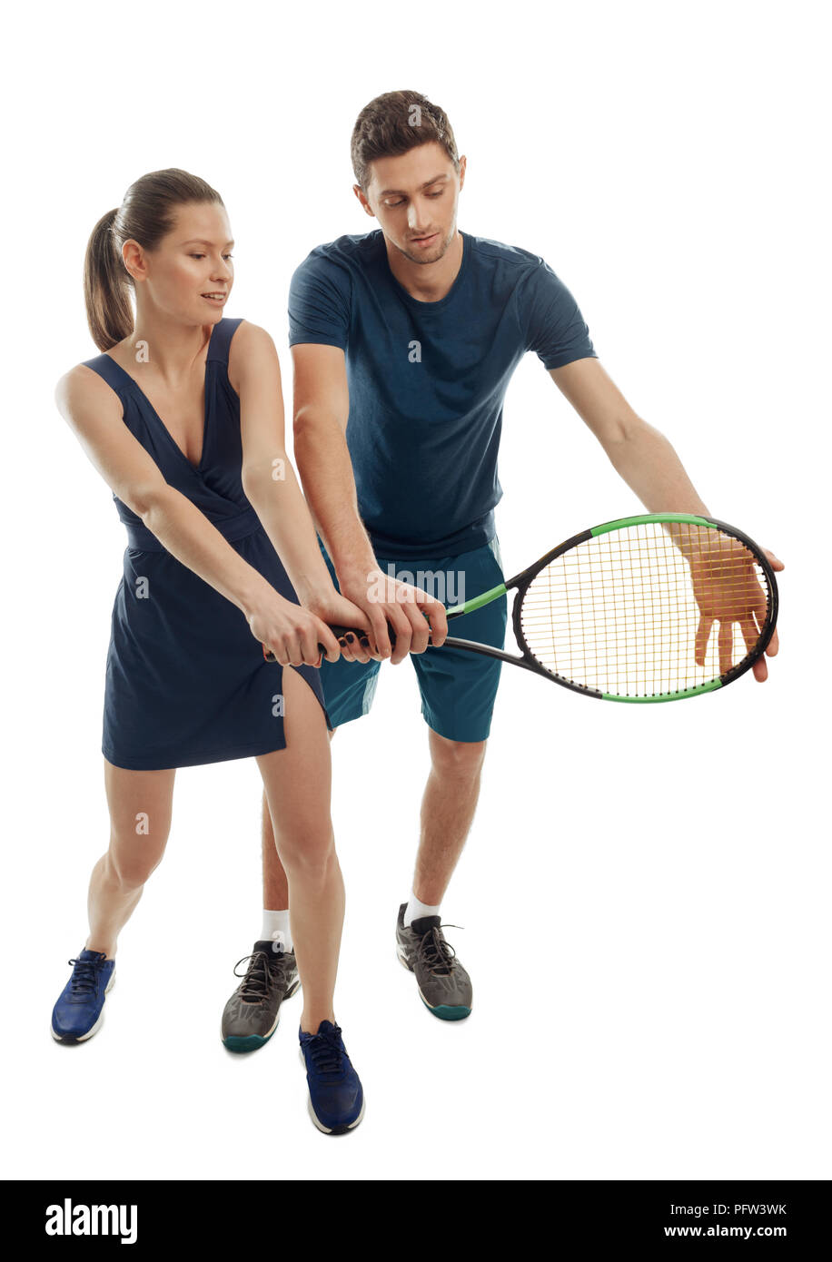Trainer teaches beginner the tennis fundamentals. Young sportive people ...