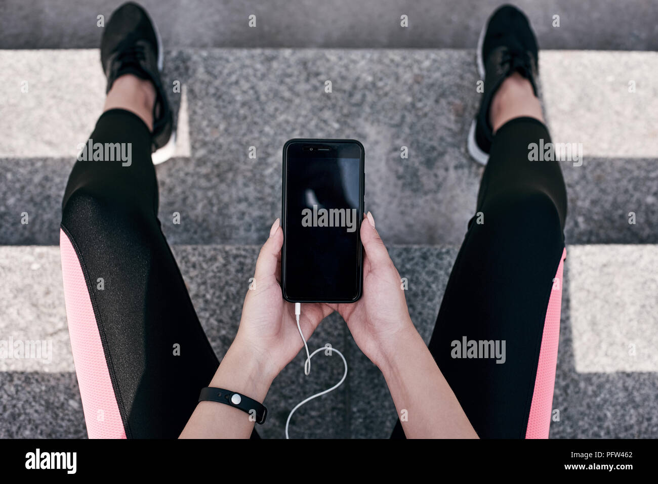 Fitness runner on mobile smart phone app tracking progress listening to ...