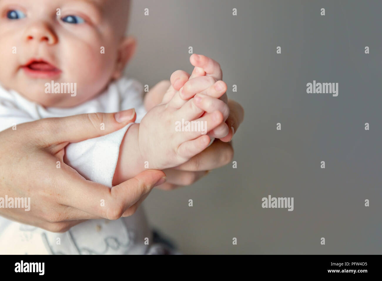 Young mother and newborn child clap their hands. Woman and infant new ...