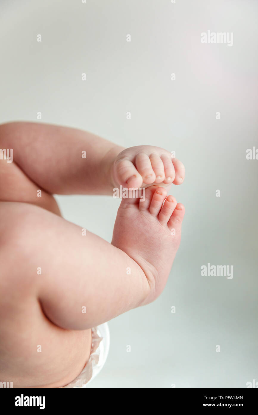 Tiny newborn infant male or female baby feet and toes on white ...