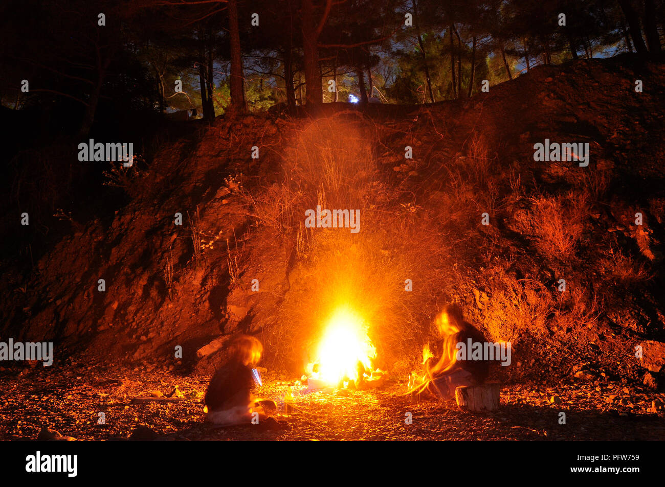 Hiking tourists have a rest around camp fire in mountains night Stock ...