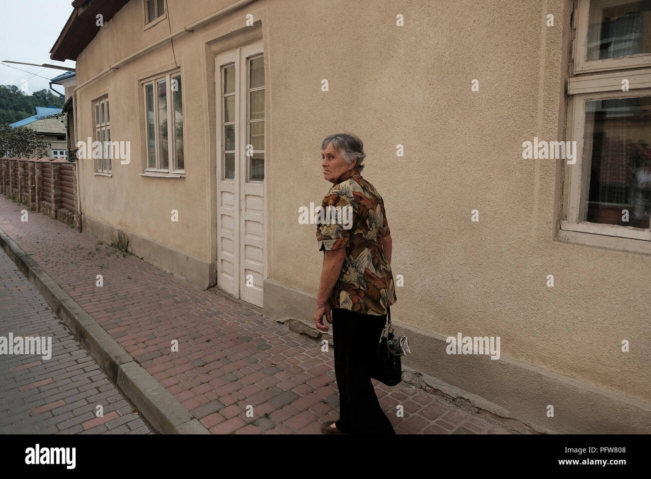 Pedestrian walks past a former Jewish house in the city of Chortkiv ...