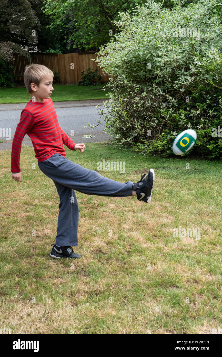 Child kicking a ball hi-res stock photography and images - Alamy