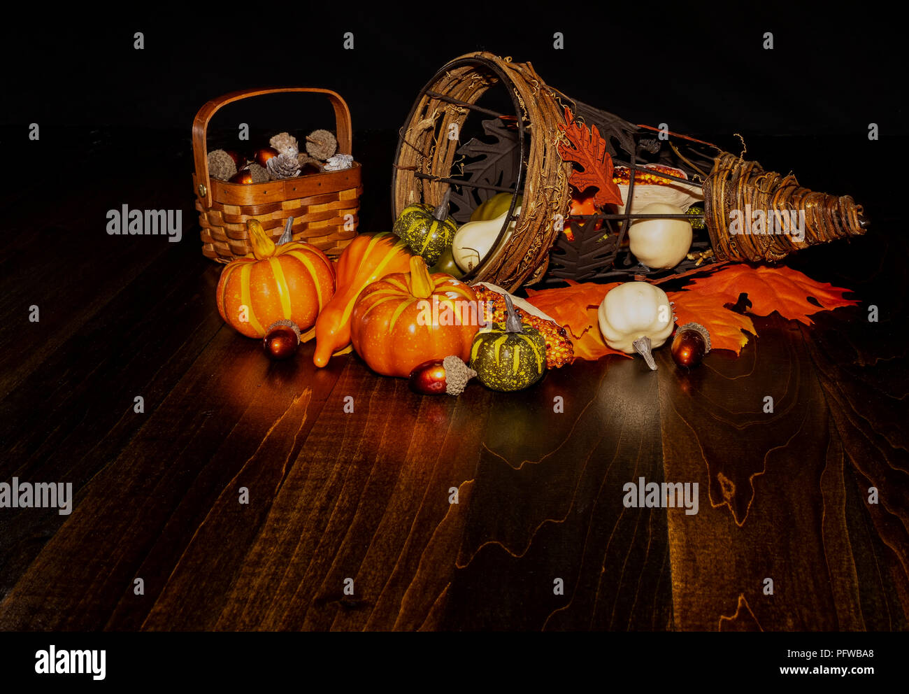 Fall harvest items are seen with decorative cornucopia on table top ...