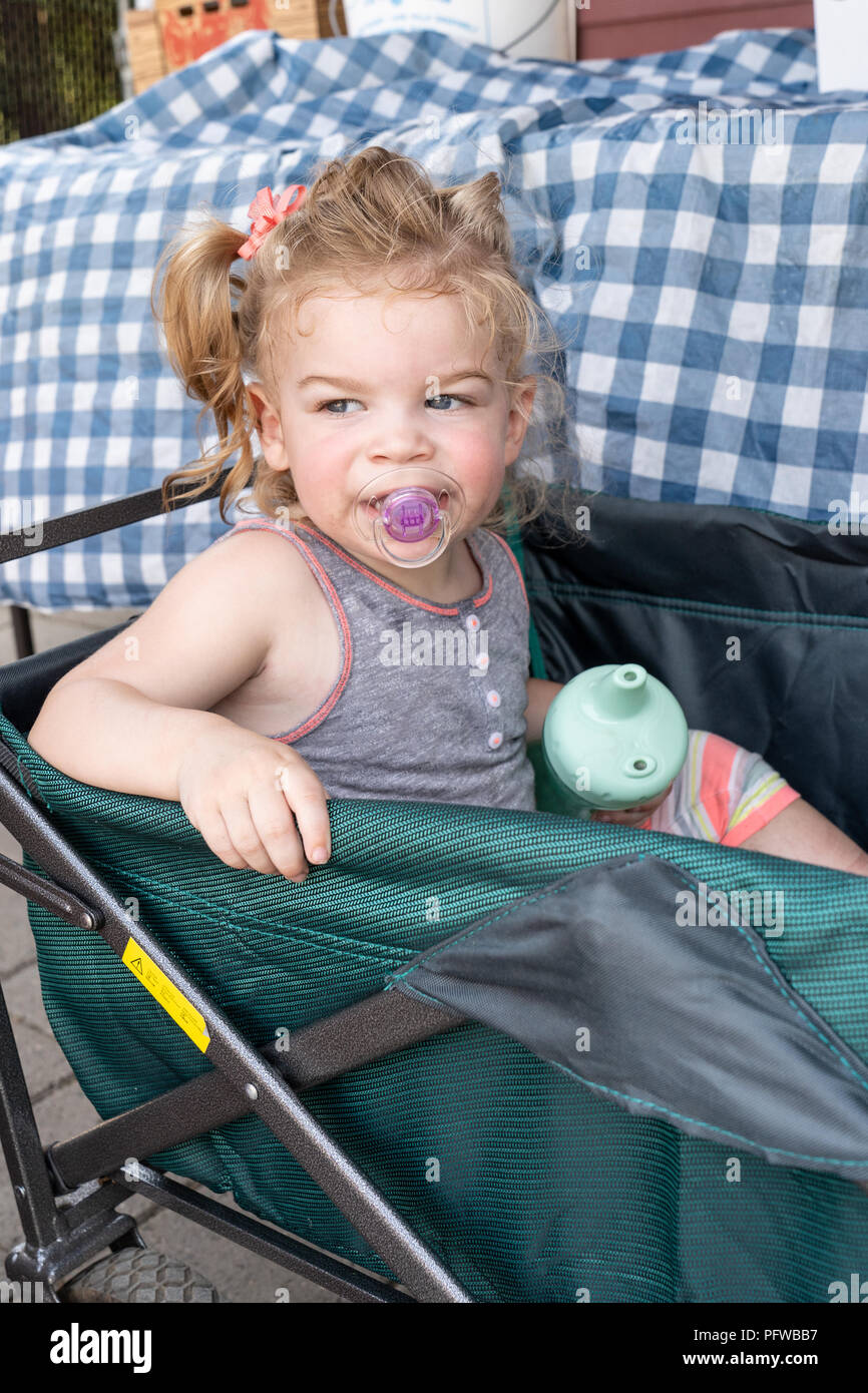 Twenty month old girl waiting in the shade in her wagon Stock Photo - Alamy