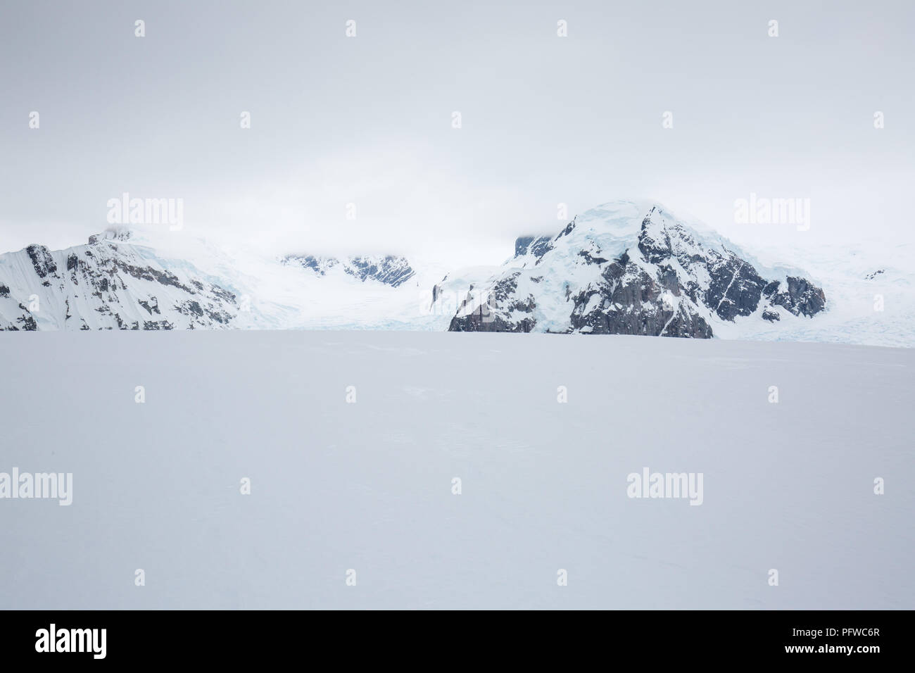 icecaps in the Antarctica with iceberg in the ocean swimming around and ...