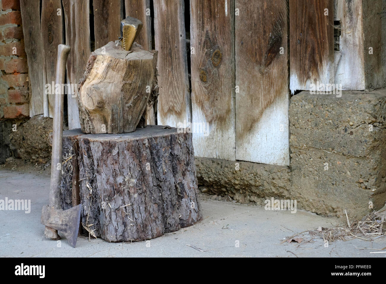 wooden log with a splitting grenade in the top sat on a chopping block ...