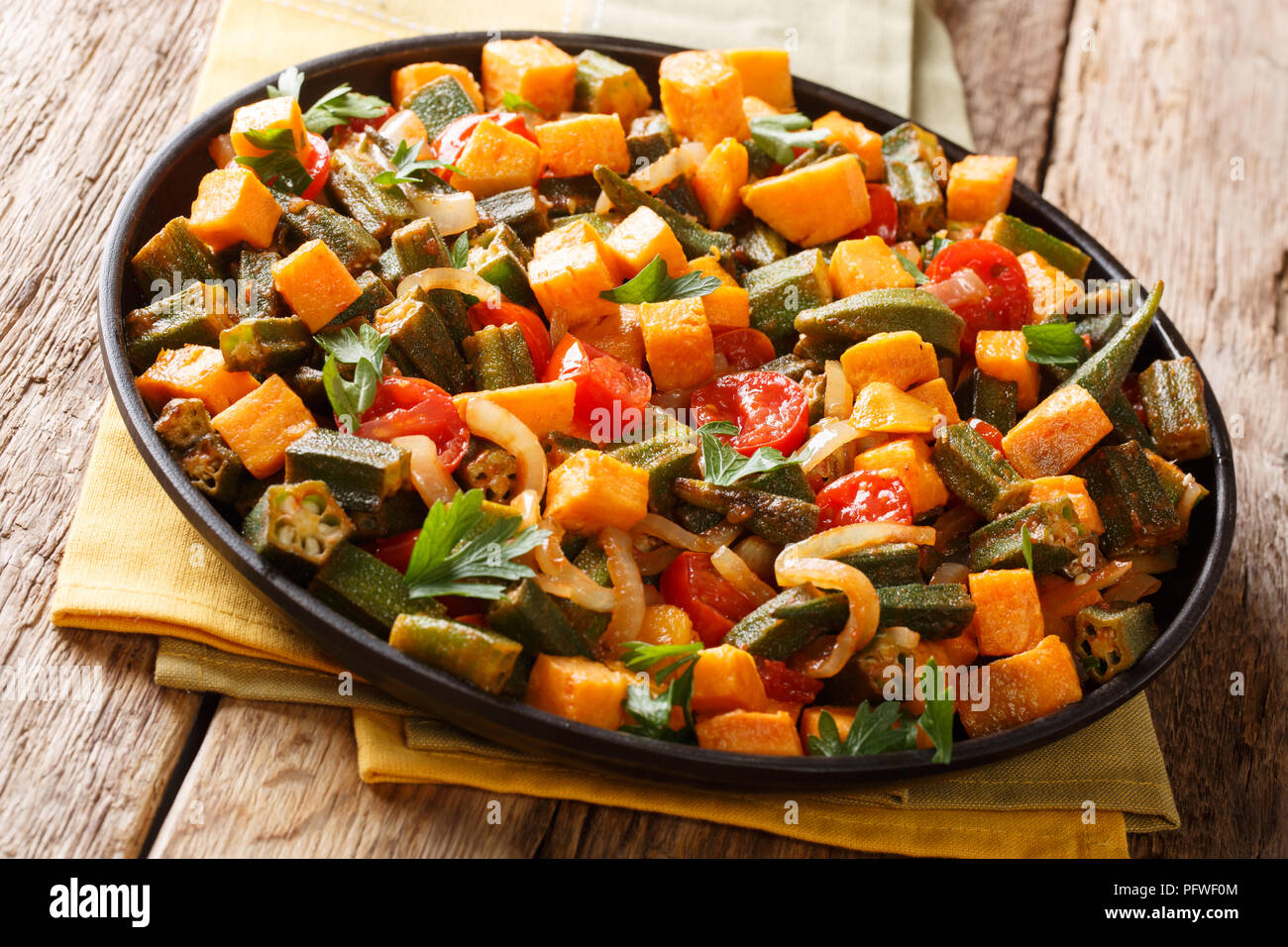 Traditional recipe ragout from okra, sweet potato, tomatoes, onions and ...