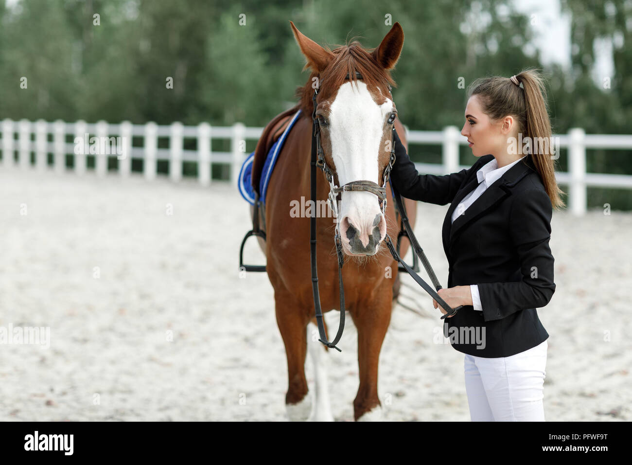 Portrait of rider elegant woman talking to her horse outside. jockey ...