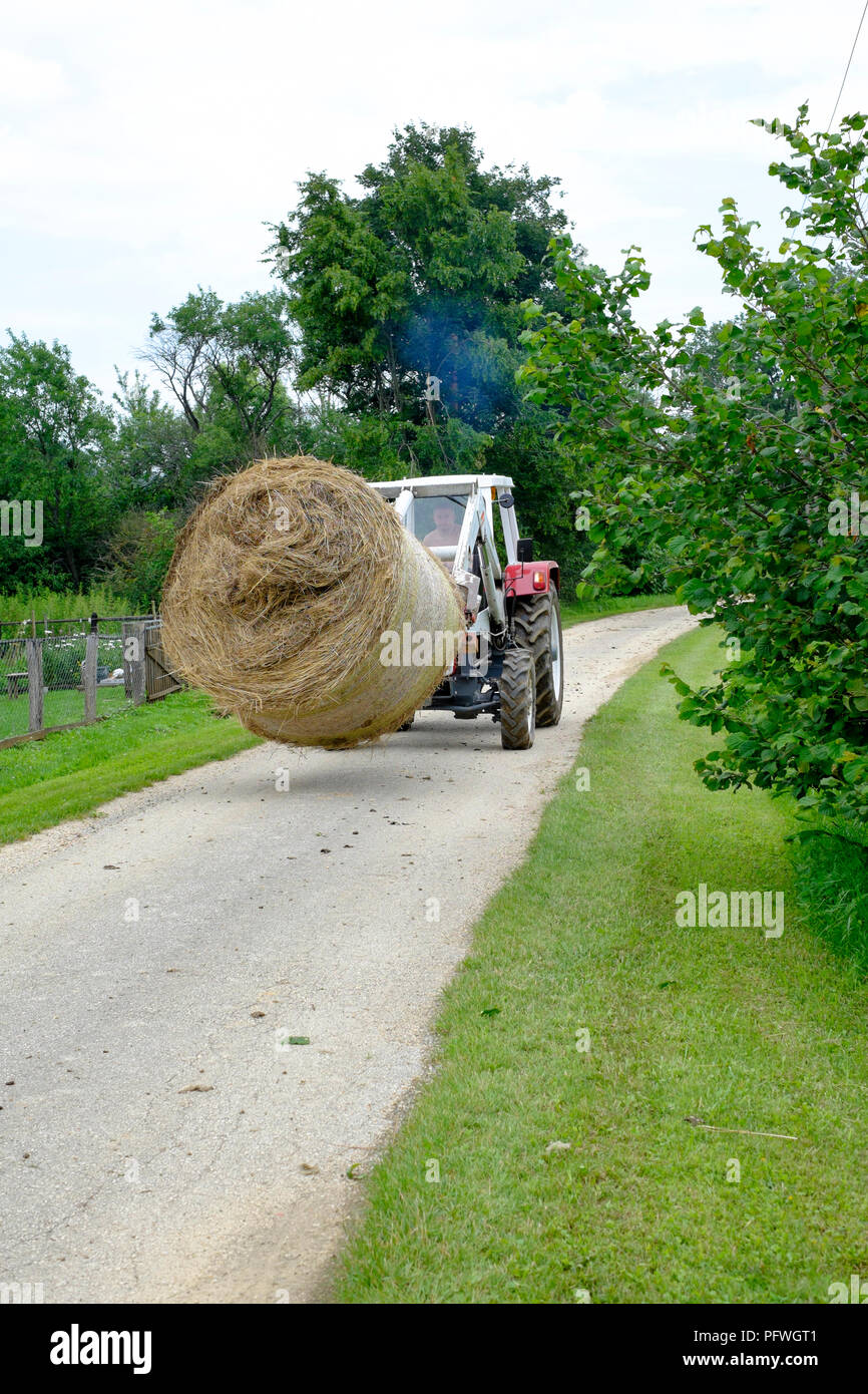 steyr 650 tractor driving through rural hamlet on country lane with ...