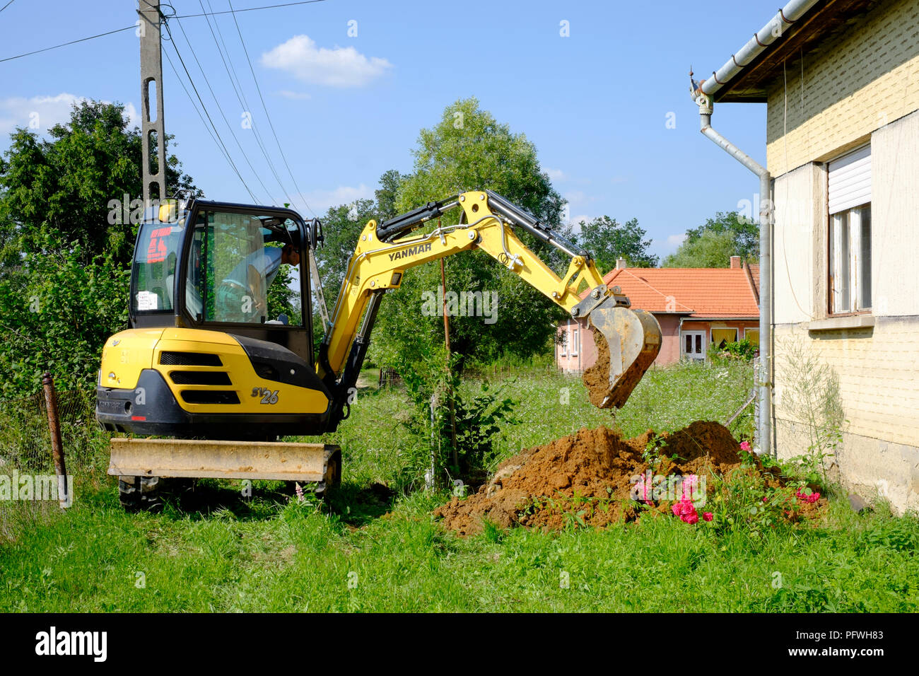 man using a mechanical digger in a garden to dig a trench zala county ...