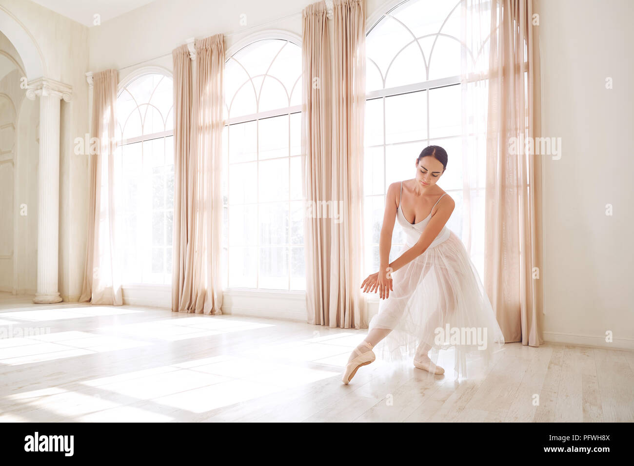 Ballerina dancing in a studio on background window Stock Photo - Alamy