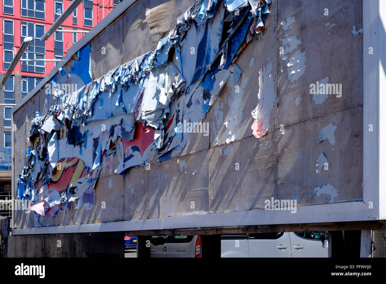 multiple layers of torn advertisements on a large billboard england uk ...