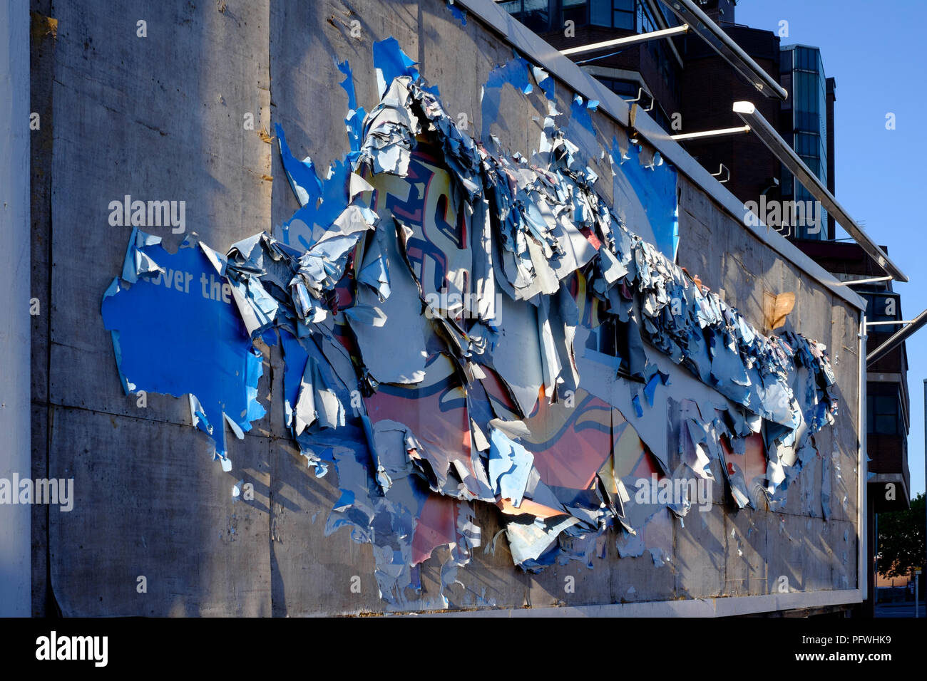 multiple layers of torn advertisements on a large billboard england uk ...