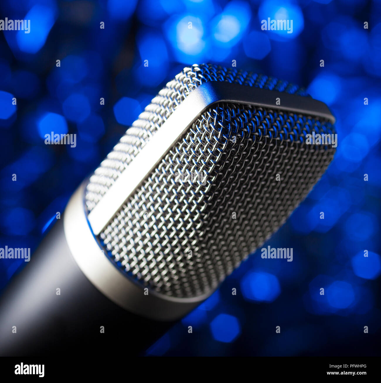 Blue background behind a microphone with wire mesh covering Stock Photo ...