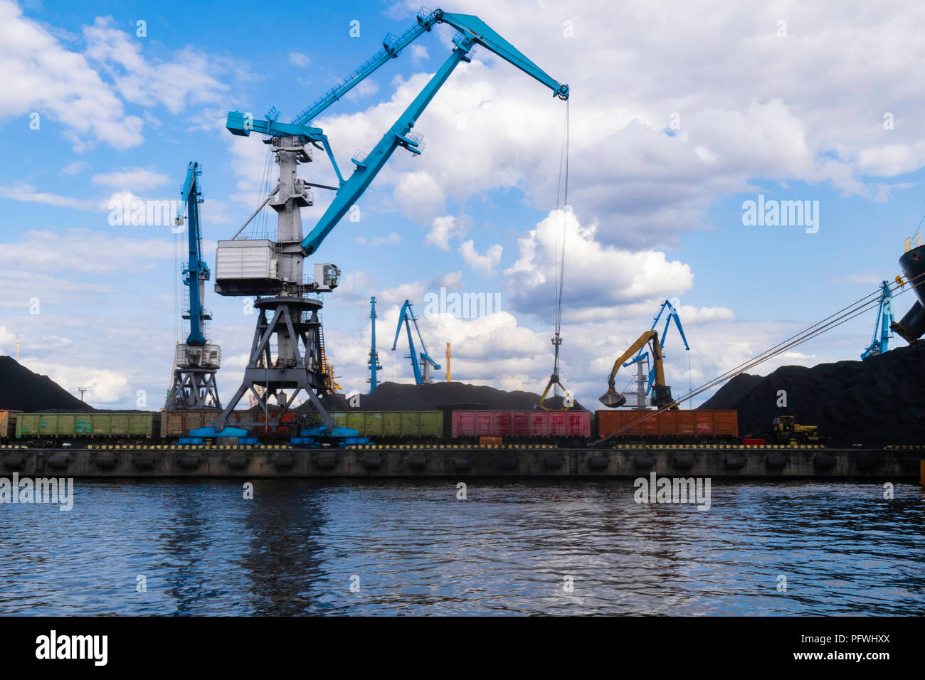 Large red cargo ship loading with a coal in the port, terminal, crane ...