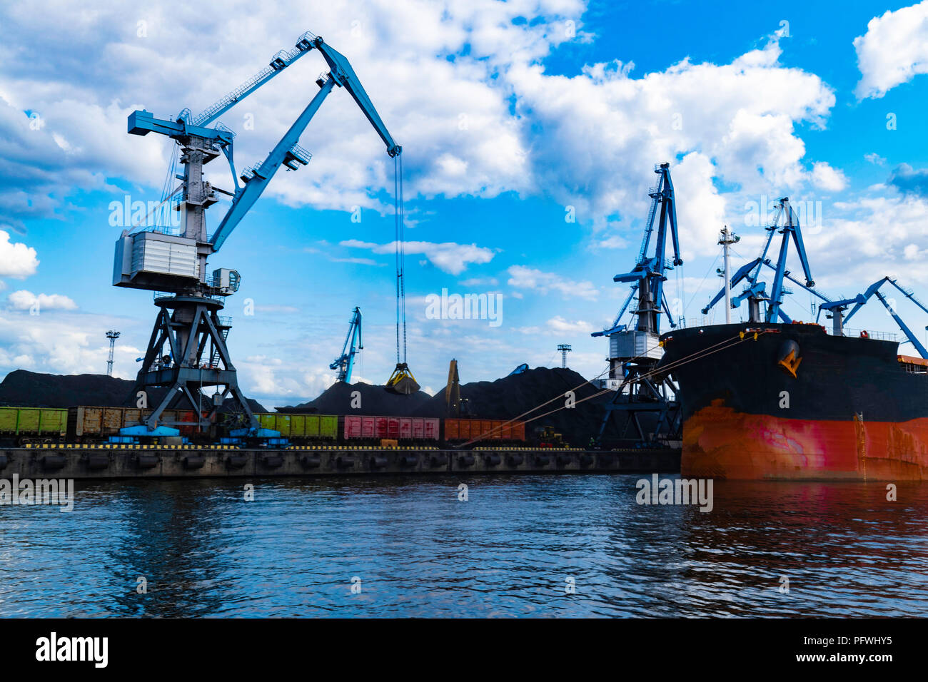 Large red cargo ship loading with a coal in the port, terminal, crane ...