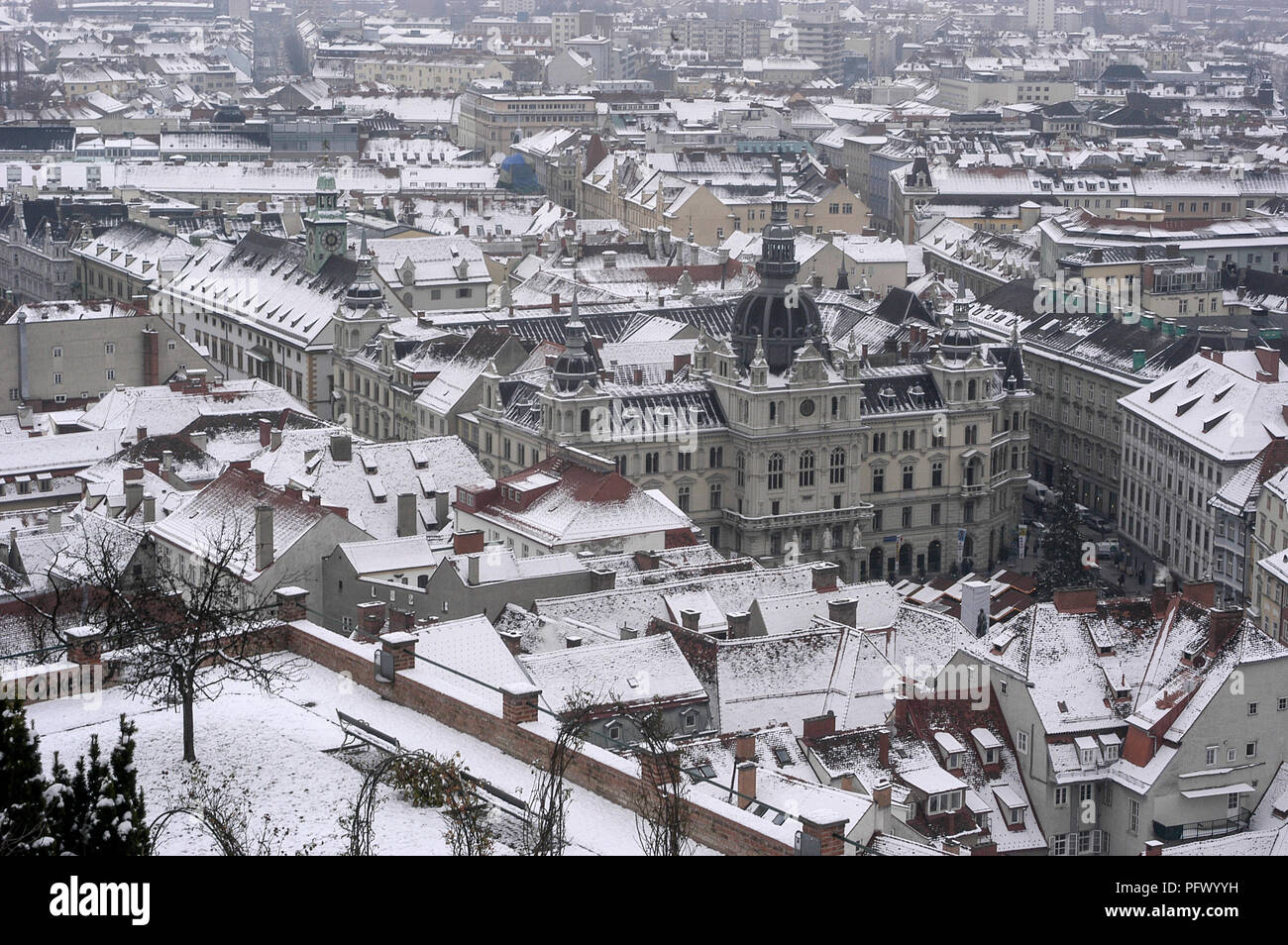 The dome high above the snow-covered roofs is the Graz City Hall in the ...