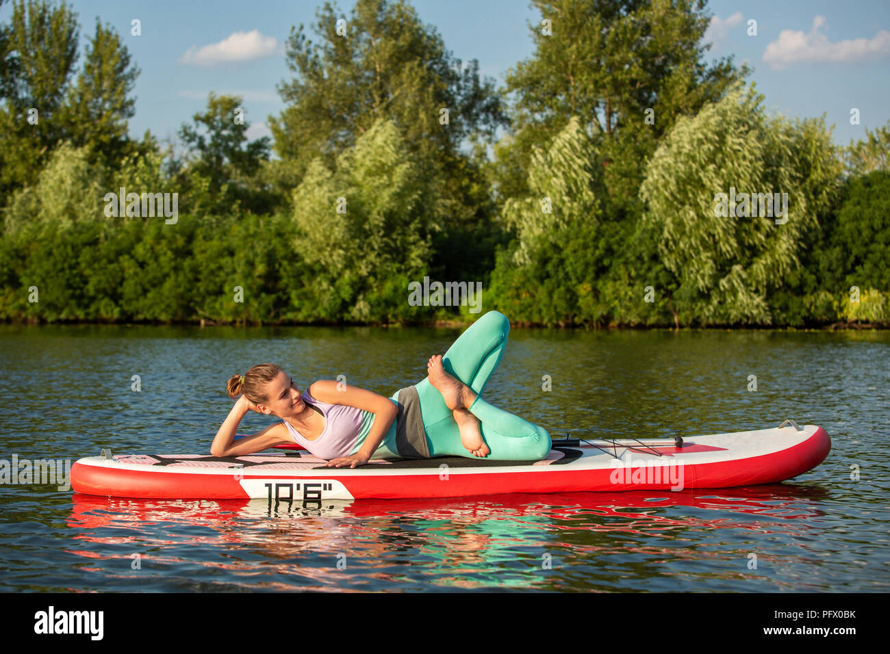 Woman practicing yoga on the paddle board in the morning Stock Photo ...