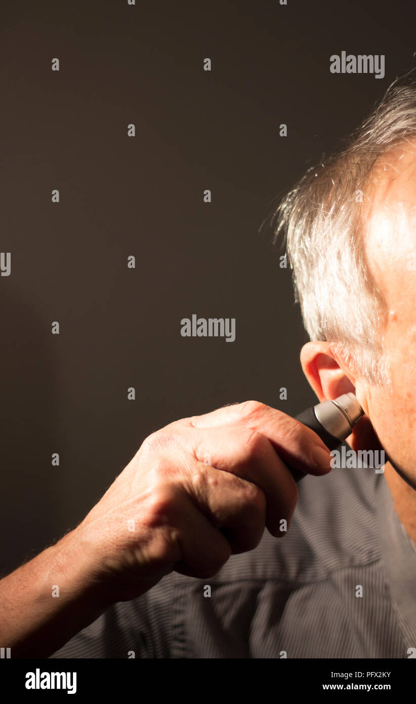 Senior citizen man cutting inner ear hair with electric cutter Stock ...