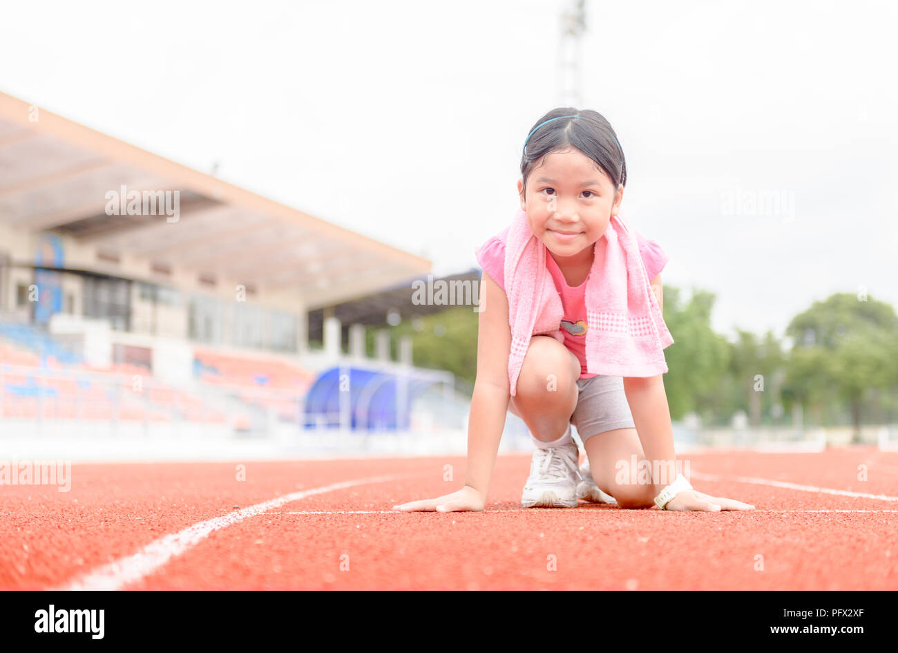 Cute girl in starting position ready for running. kid athlete about to ...