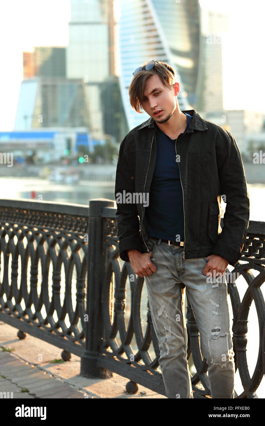 Thinking lonely handsome young man walking in fashion jeans and black ...