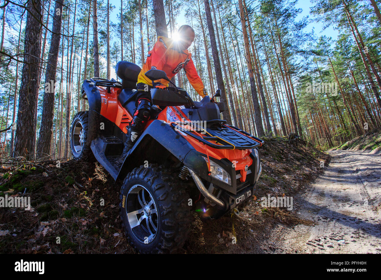 Man rises a quad bike in the forest Stock Photo - Alamy