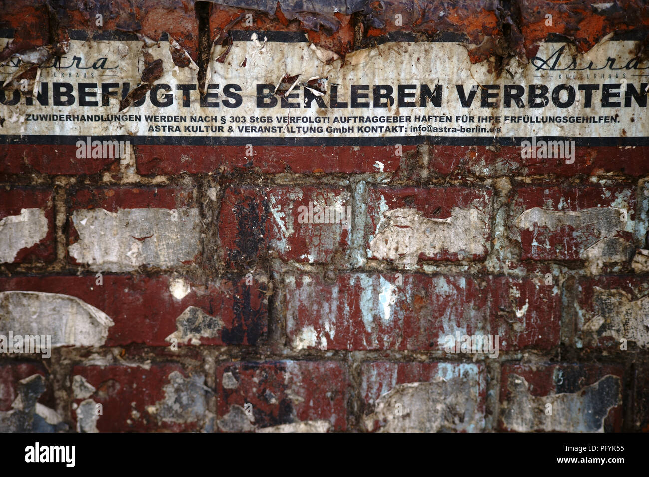 The worn facade of a brick building with peeling paper scraps Stock ...
