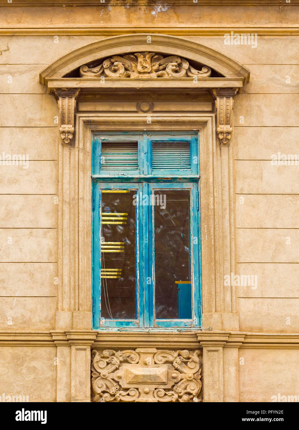 View of the window with a bas-relief on the facade of the building ...