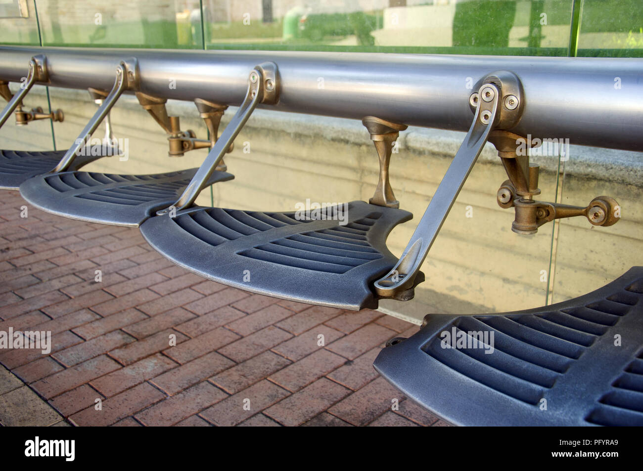 Silver metalic designed seats in the bus stop, summer Stock Photo - Alamy