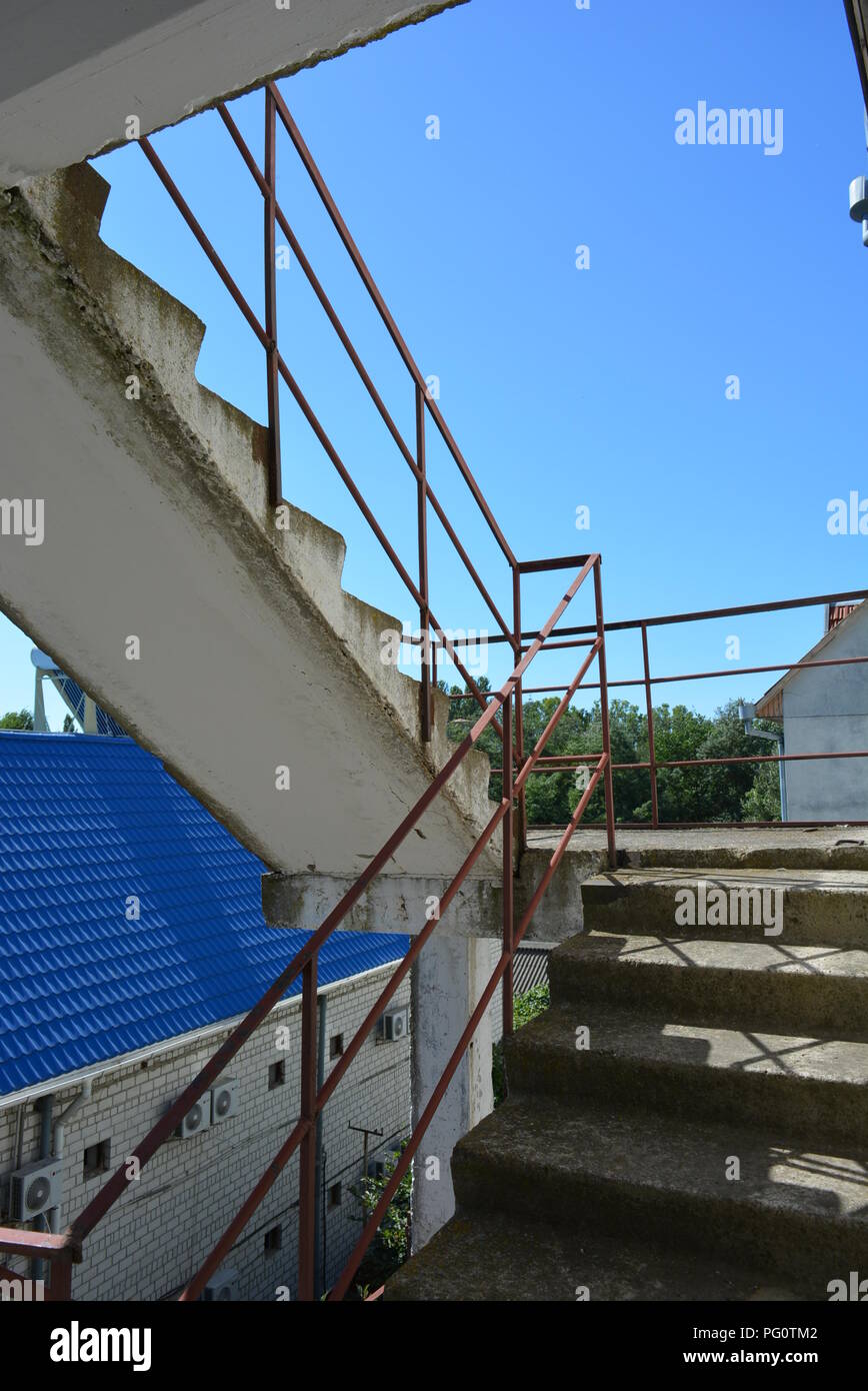 Emergency fire concrete staircase with metal handrails in the sunlight ...