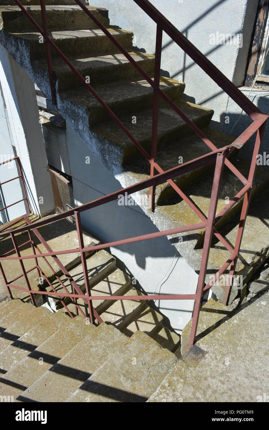 Emergency fire concrete staircase with metal handrails in the sunlight ...