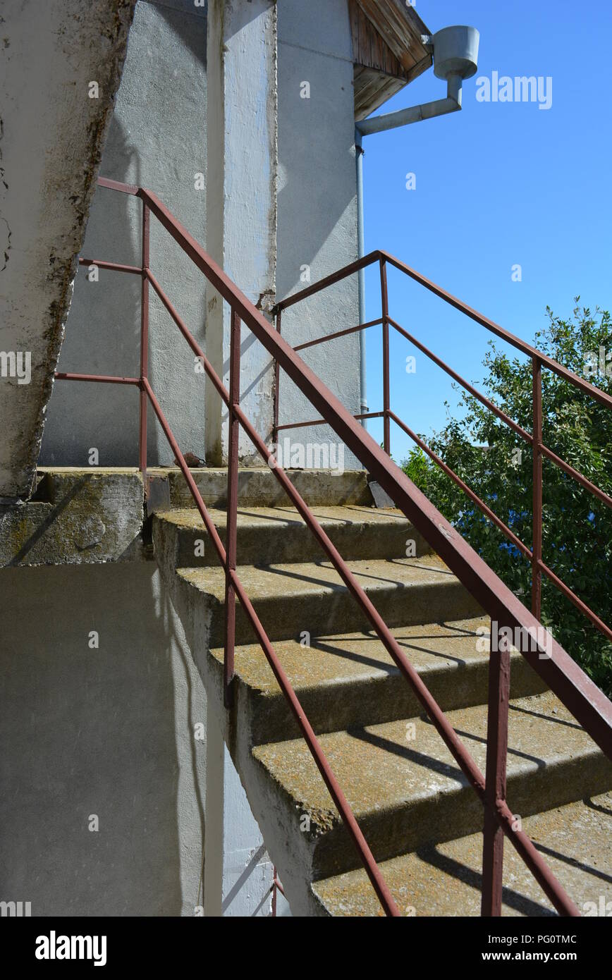 Emergency fire concrete staircase with metal handrails in the sunlight ...
