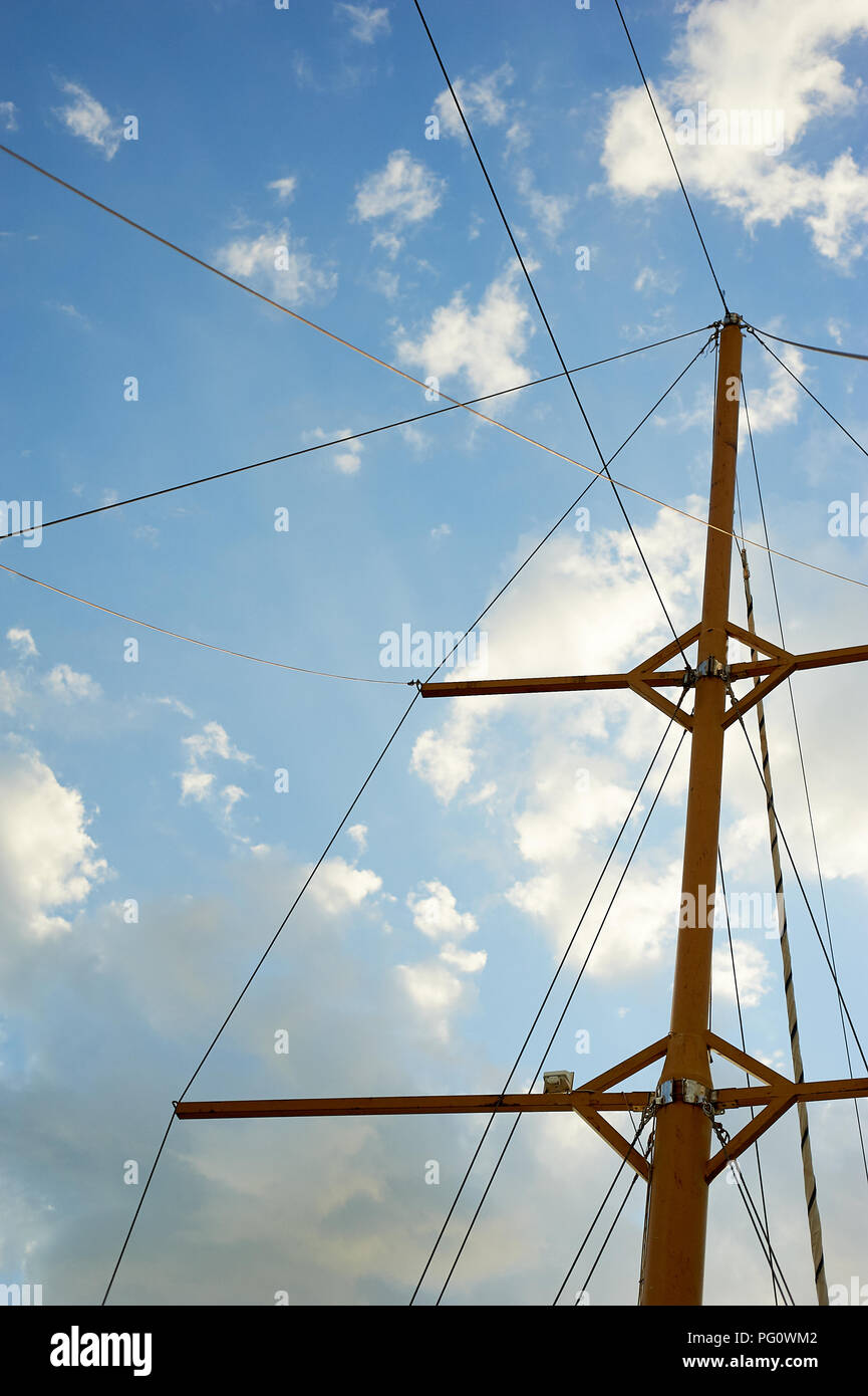 The wooden mast of an old ship on the background of blue sky. Going out ...