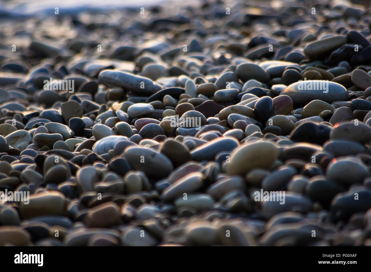 pebble stones on the sea beach on a warm summer day, the rolling waves ...