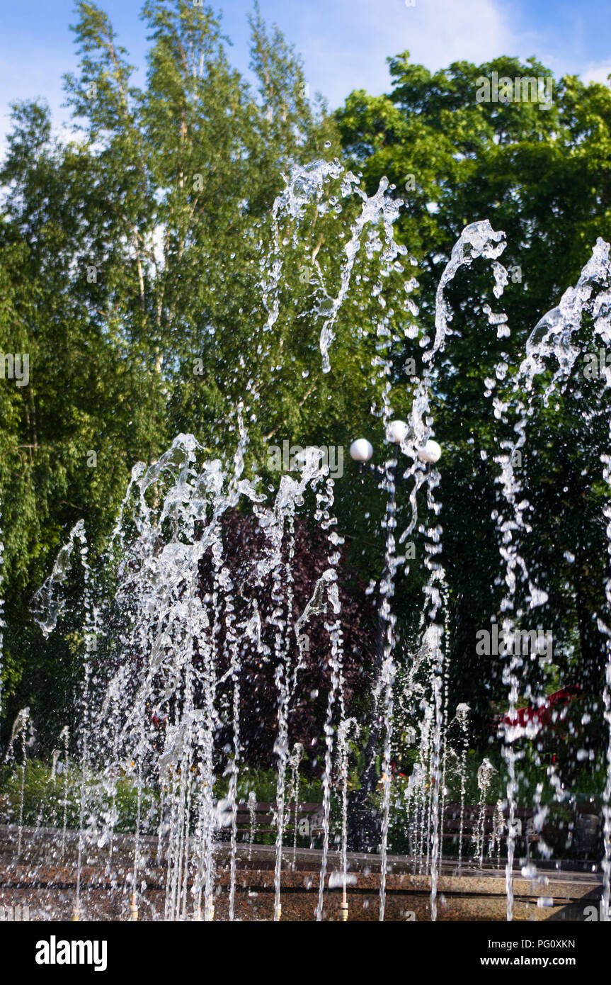 Fountain in city park on hot summer day, beautiful bright streams of ...