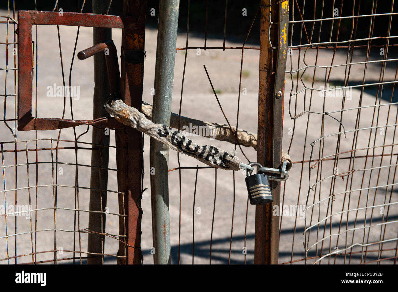 Padlock and chain on dilapidated gates Stock Photo - Alamy