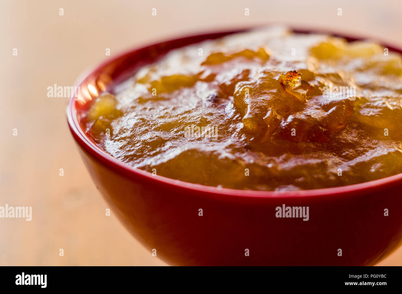 Transparent Apple sweet homemade jam in the red ceramic bowl on wooden ...