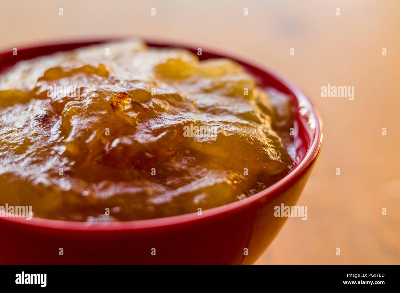 Transparent Apple sweet homemade jam in the red ceramic bowl on wooden ...