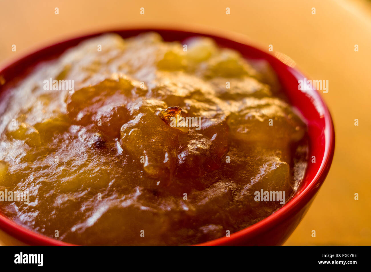 Transparent Apple sweet homemade jam in the red ceramic bowl on wooden ...
