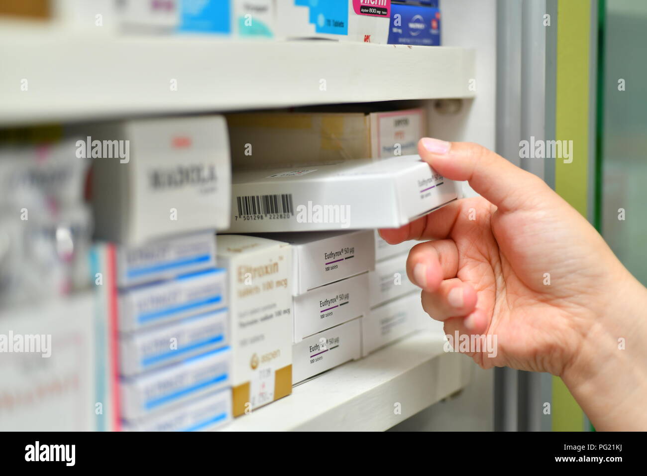 Closeup pharmacist hand holding medicine box in pharmacy drugstore ...